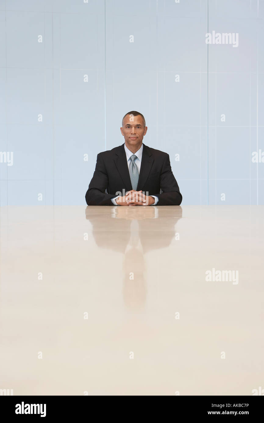 Business man sitting at end of conference table, portrait Stock Photo ...