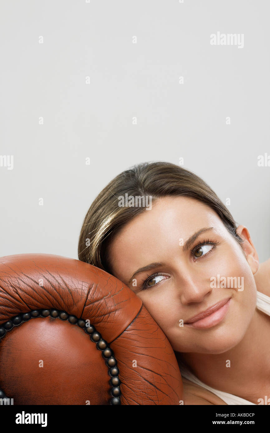 Young woman with head leaning against sofa Stock Photo - Alamy