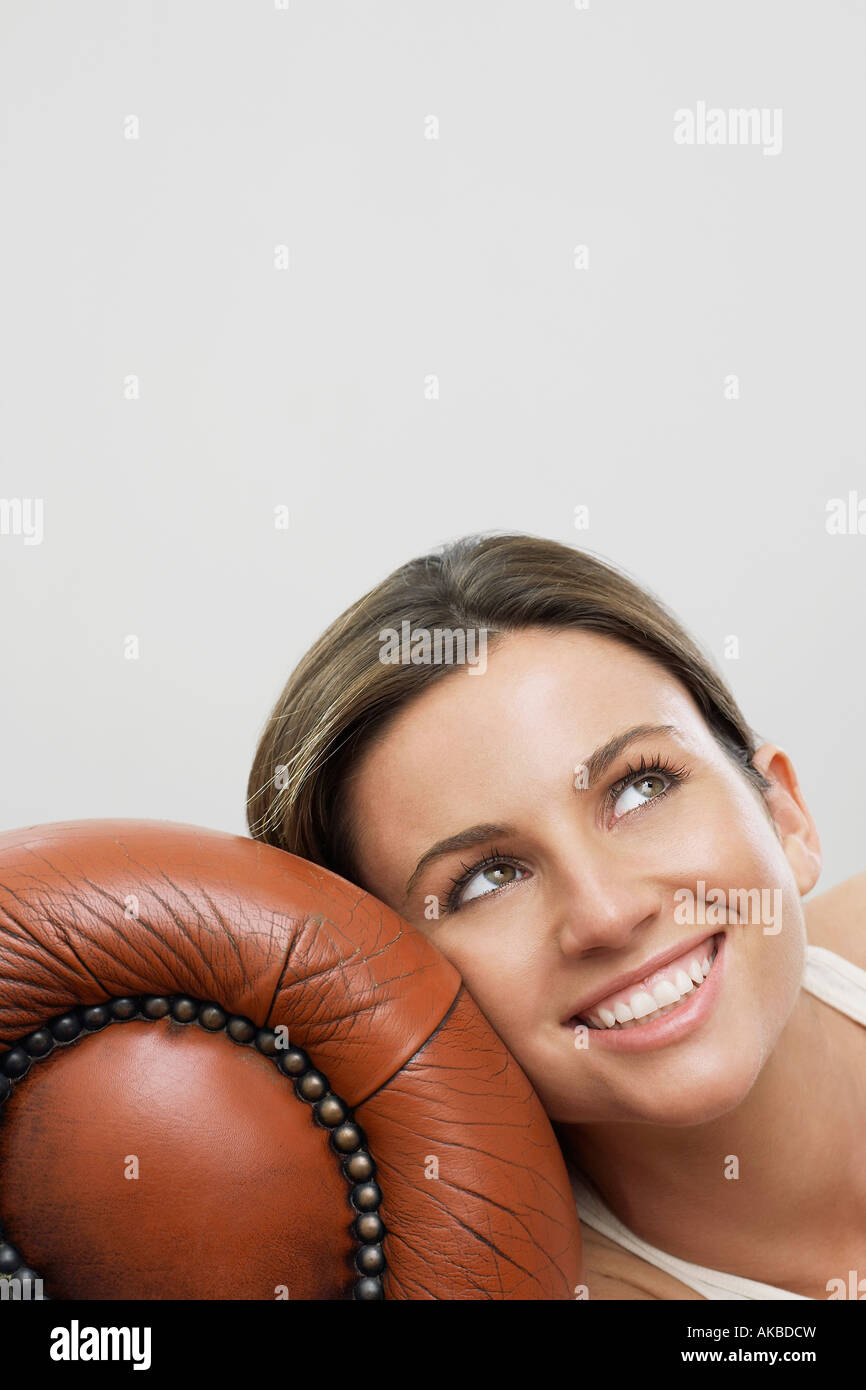 Young woman with head leaning against sofa Stock Photo - Alamy