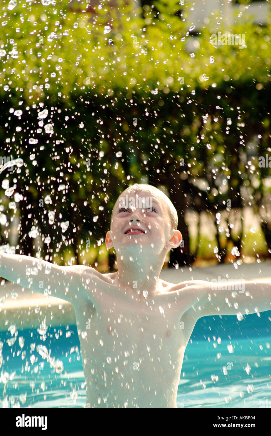 Boy playing in swimming pool backlit Stock Photo - Alamy