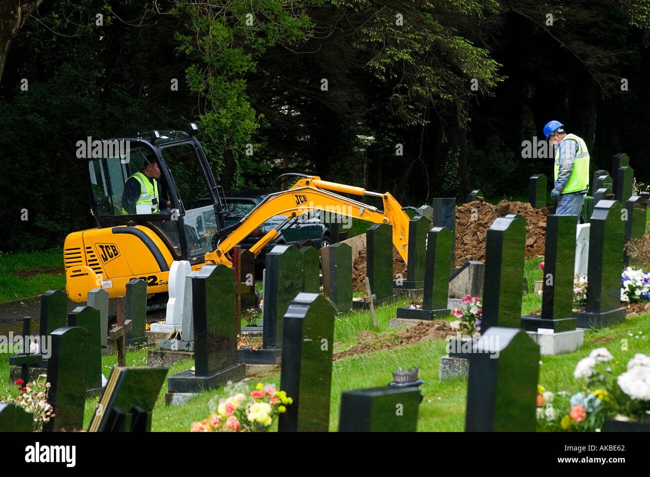 Mechanical Gravedigger at work in a hillside cemetery Stock Photo - Alamy