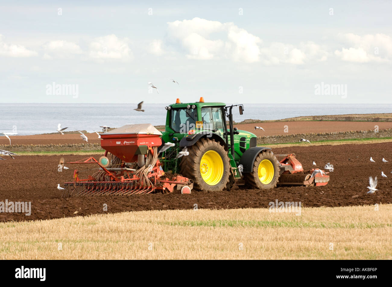 Tractor seeding field in Scotland Stock Photo - Alamy