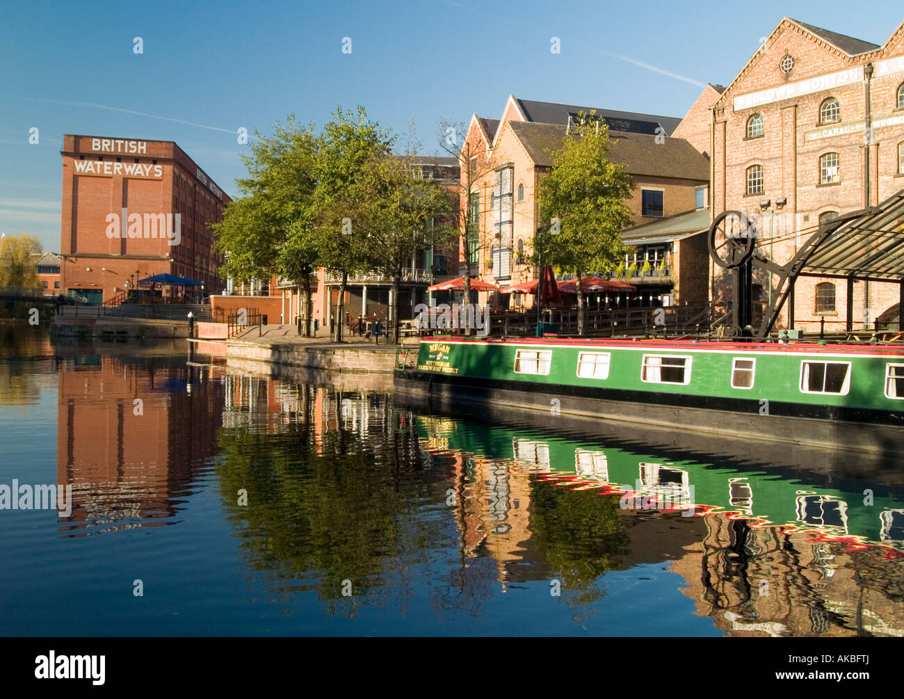 Buildings and Long Boats reflected in the canal at the waterfront in ...