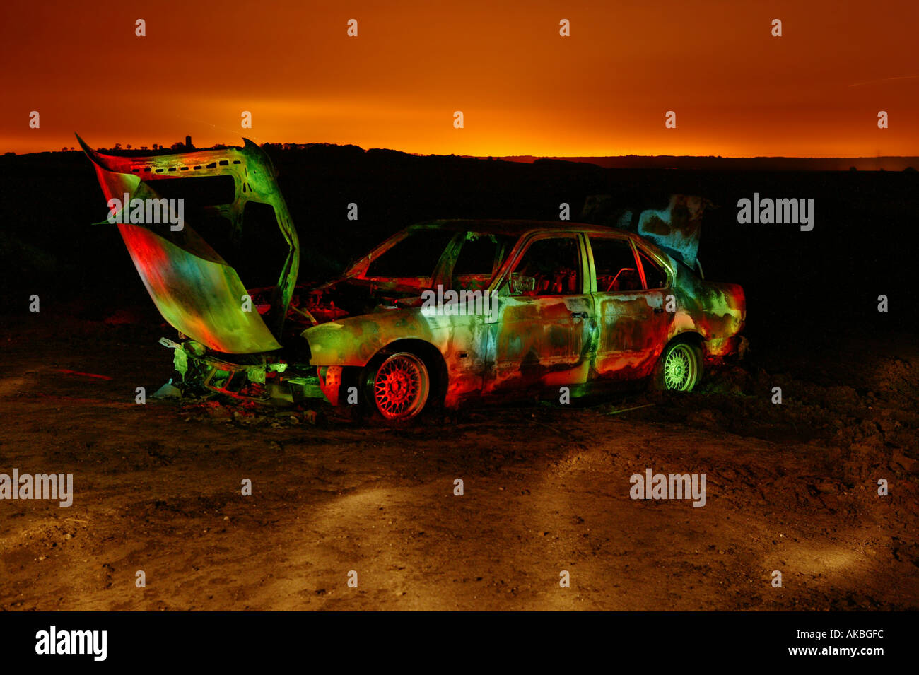 Burnt out BMW painted with coloured lights Stock Photo - Alamy