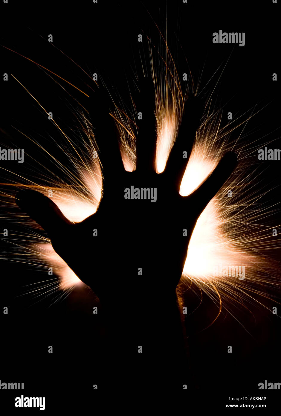 Hand silhouette lit by sparks Stock Photo - Alamy
