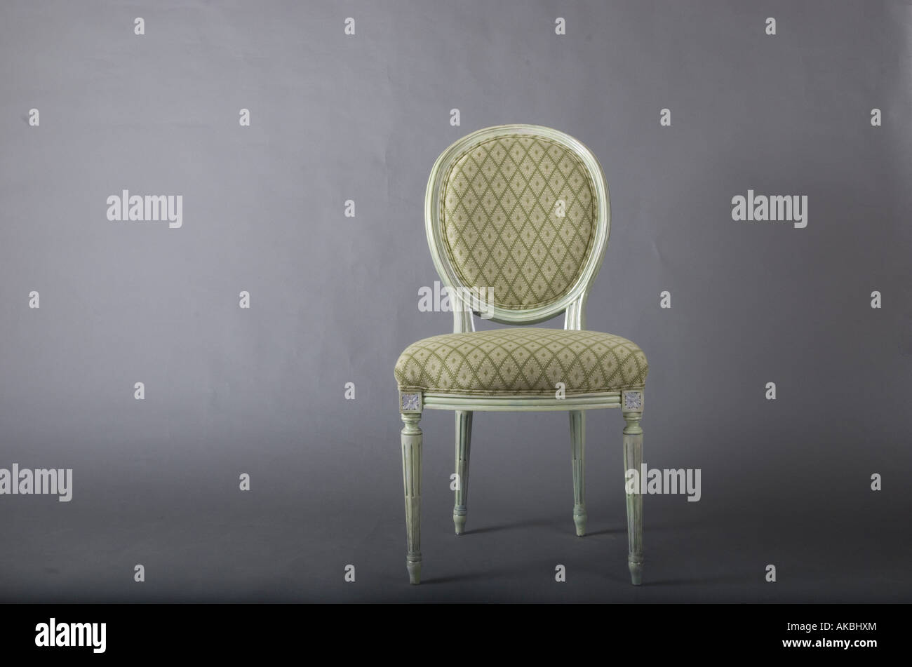 upolstered chair on gray back drop Stock Photo - Alamy