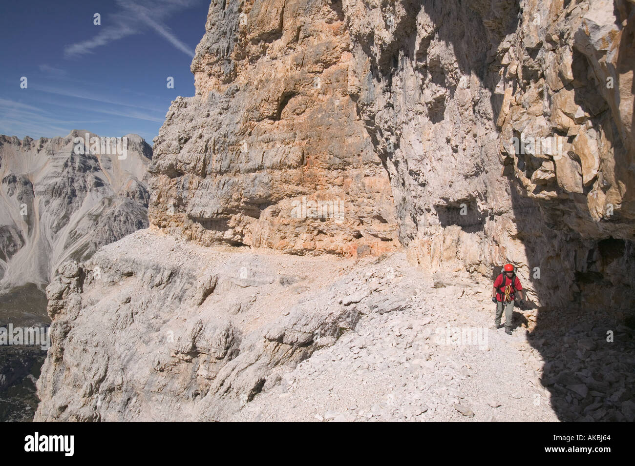 climber traversing along a ledge above an extremely exposed cliff ...