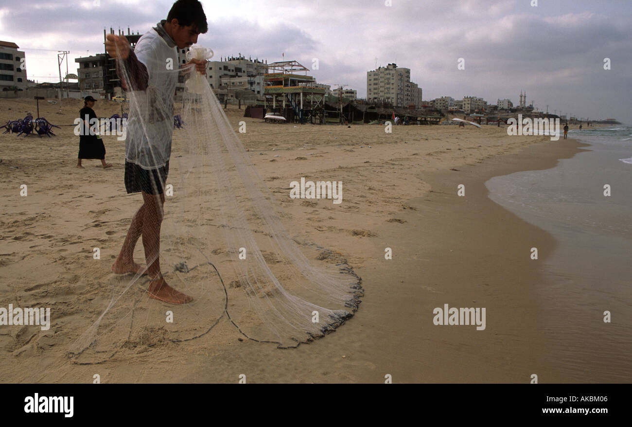 A fisherman about to cast his net by the beach Stock Photo - Alamy