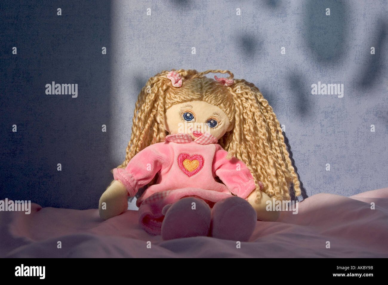 A childs doll alone in a bedroom Stock Photo - Alamy