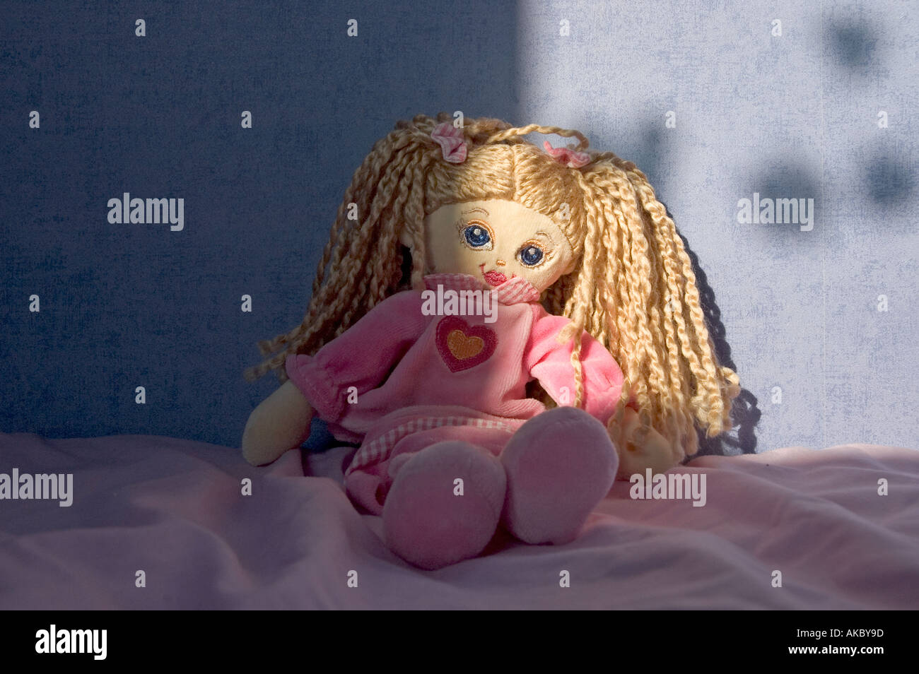 A childs doll alone in a bedroom Stock Photo - Alamy