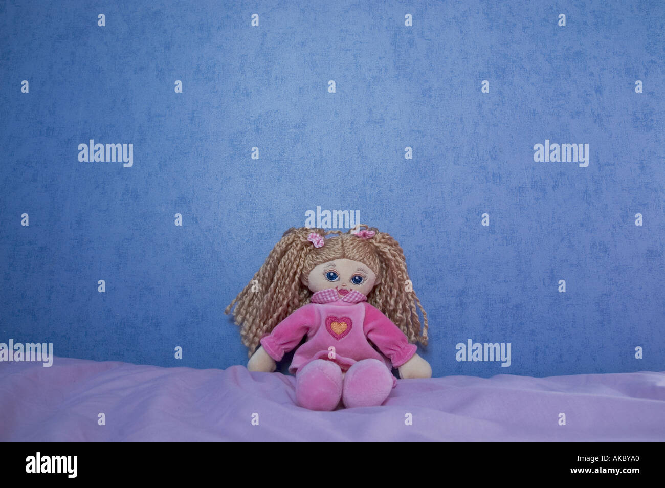 A childs doll alone in a bedroom Stock Photo - Alamy