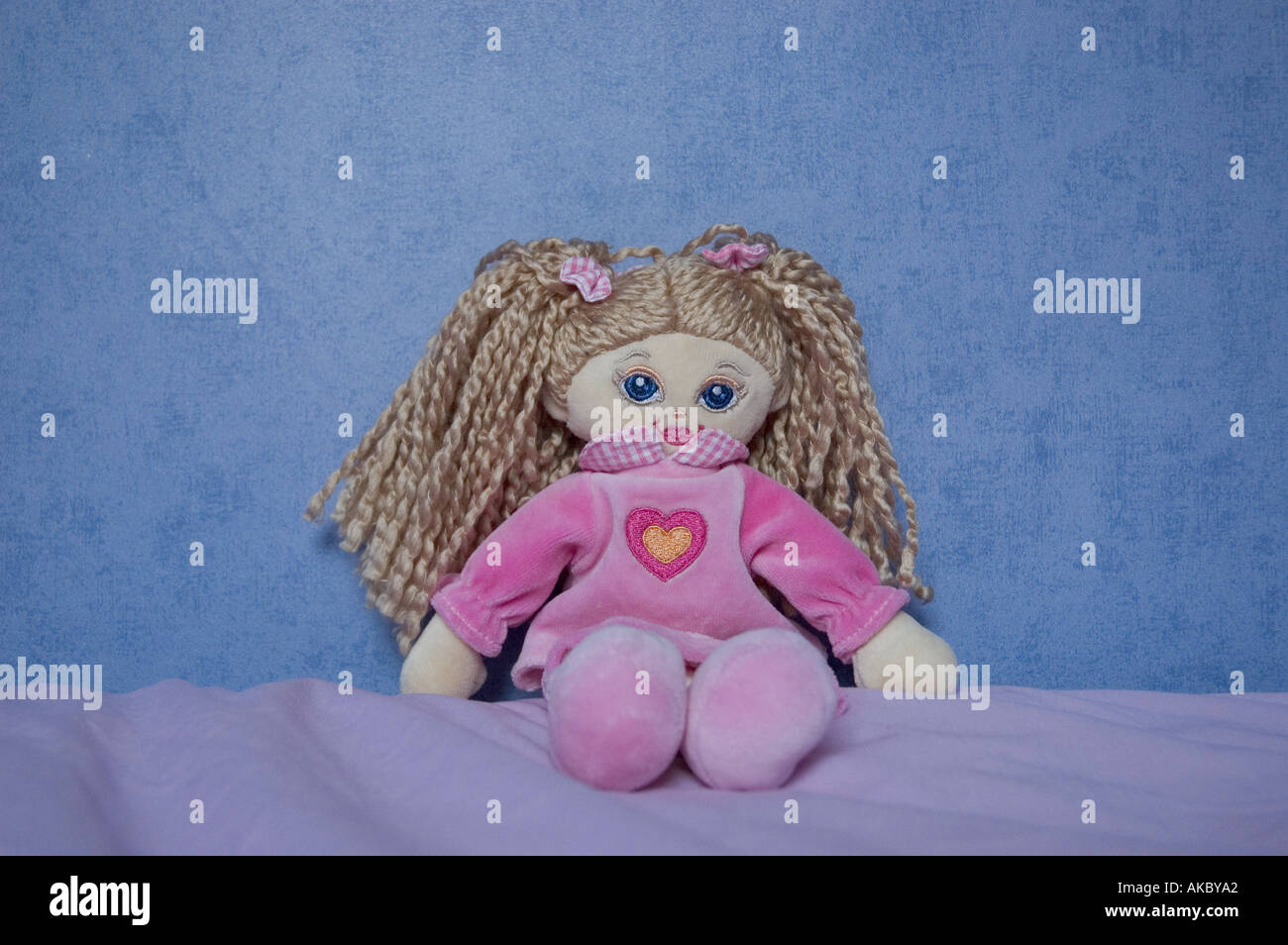 A childs doll alone in a bedroom Stock Photo - Alamy