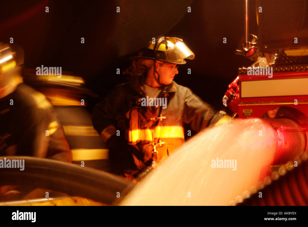 A firefighter at the controls of a water tanker valve releasing water ...