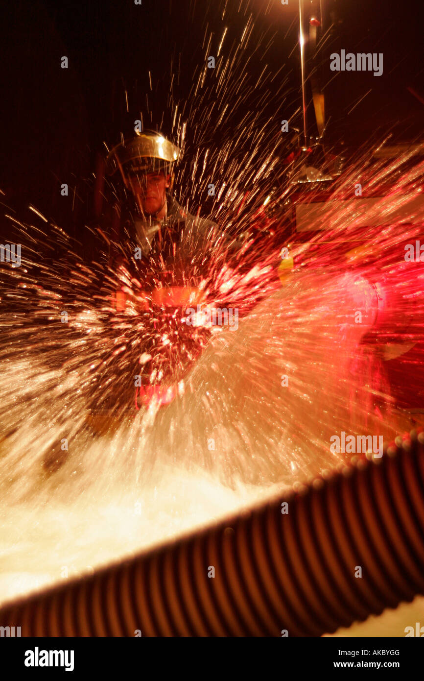 A firefighter at the controls of a water tanker valve releasing water ...