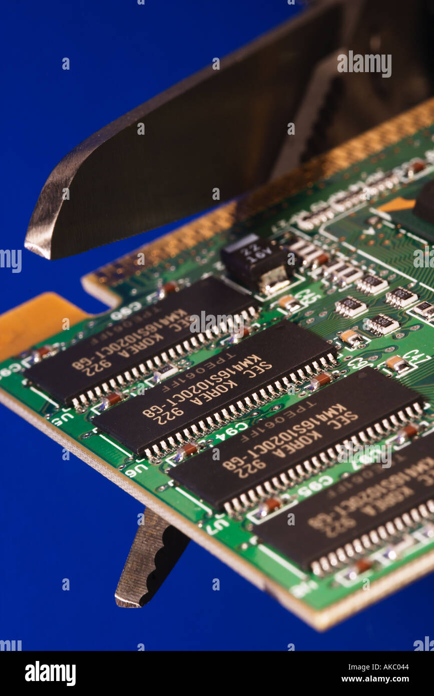 Scissors cutting edge of printed circuit board blue Stock Photo - Alamy