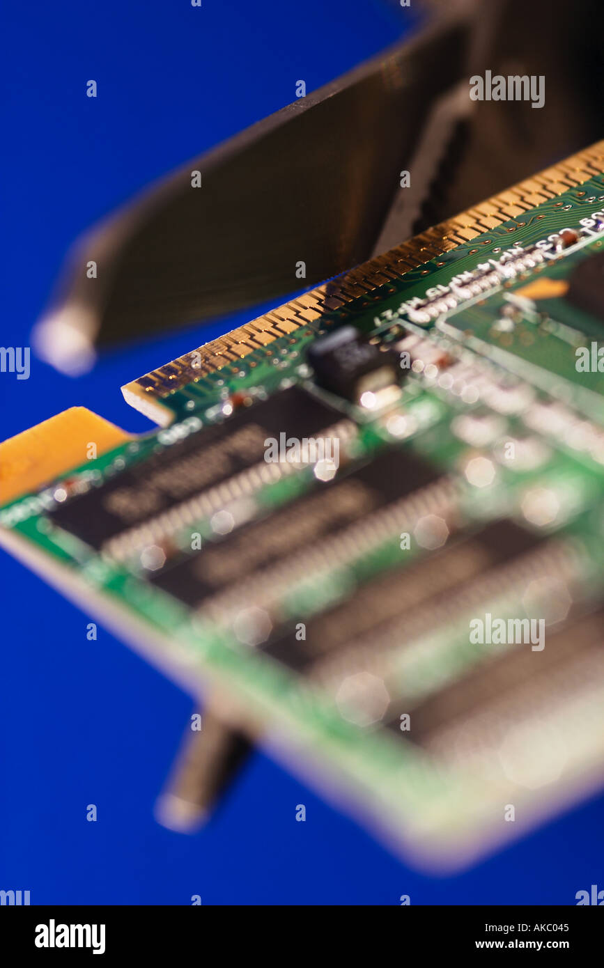 Scissors cutting edge of printed circuit board blue Stock Photo - Alamy