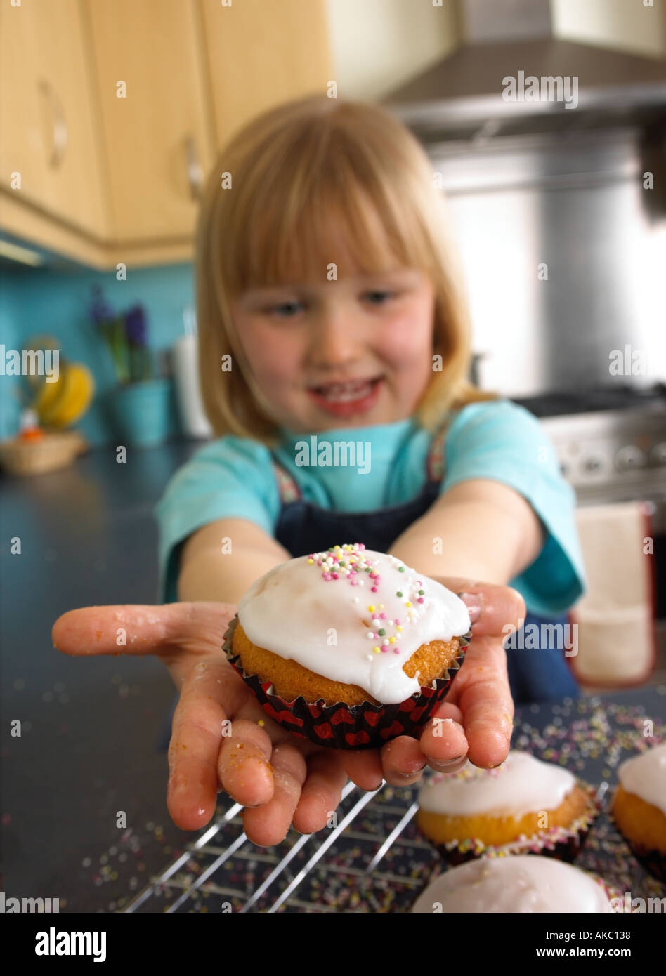 Children cooking cakes in their kitchen at home Girl showing a finished ...