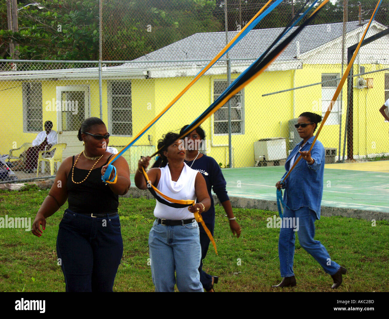 Women perform a traditional maypole dance weaving a pattern on the pole ...