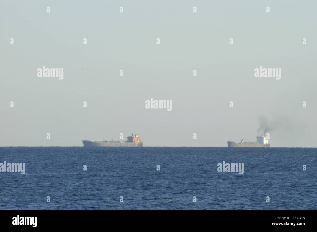 Two oil tankers on ocean in distance Stock Photo - Alamy