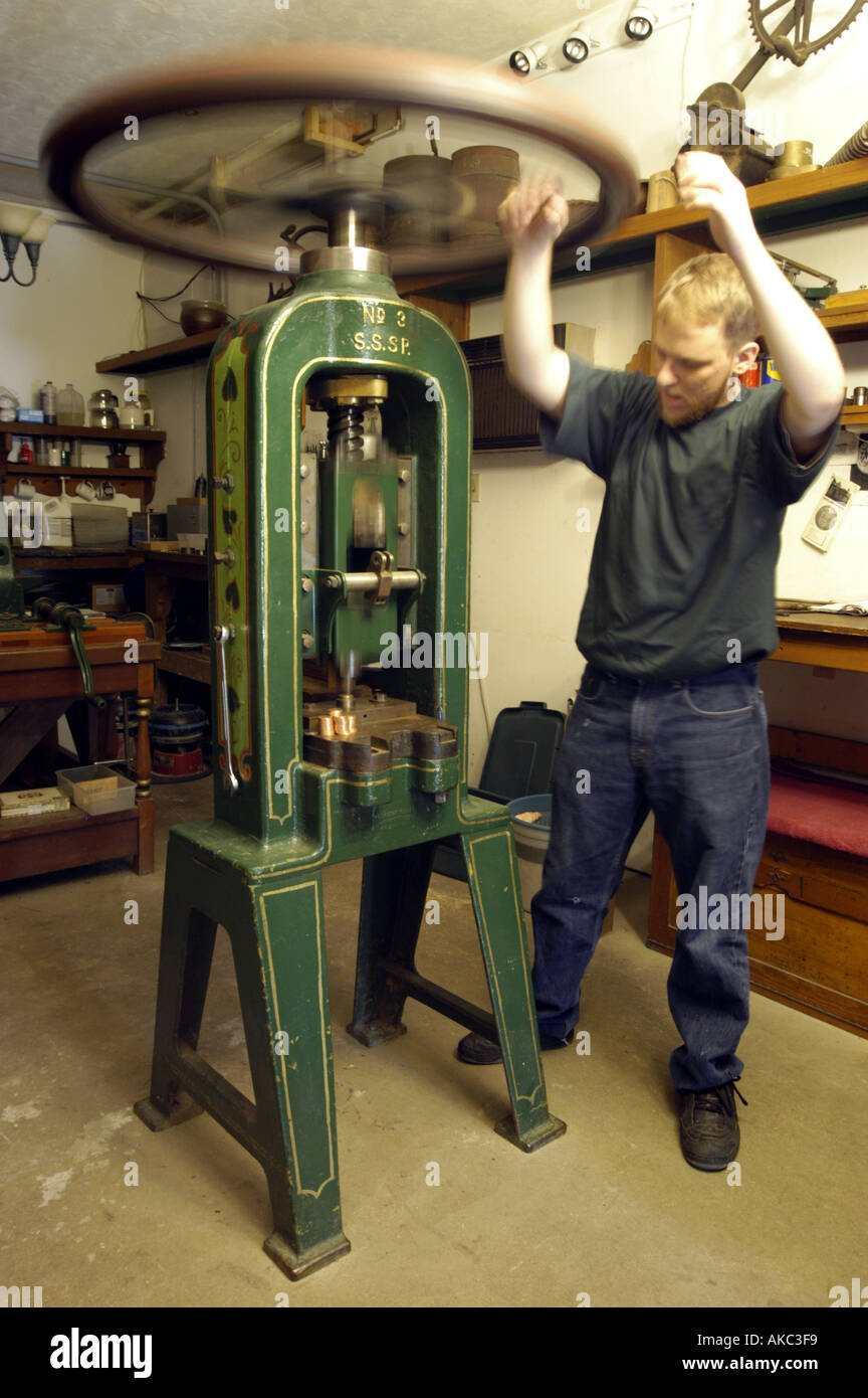 Man making a coin with old coin press Stock Photo - Alamy