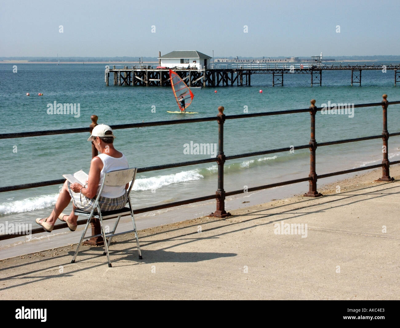 Isle of Wight woman reading a book on the promenade at Totland Bay ...