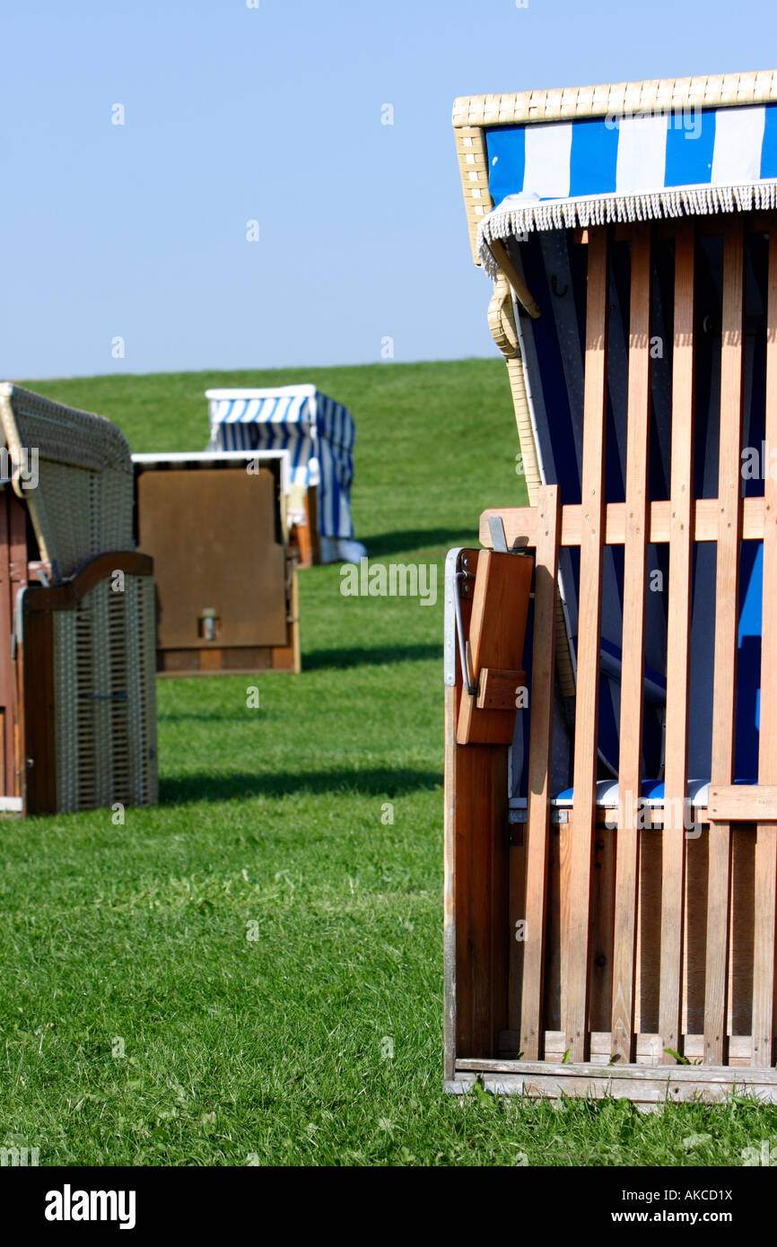 Roofed wicker beach chairs stand on a green grassland in Buesum near ...