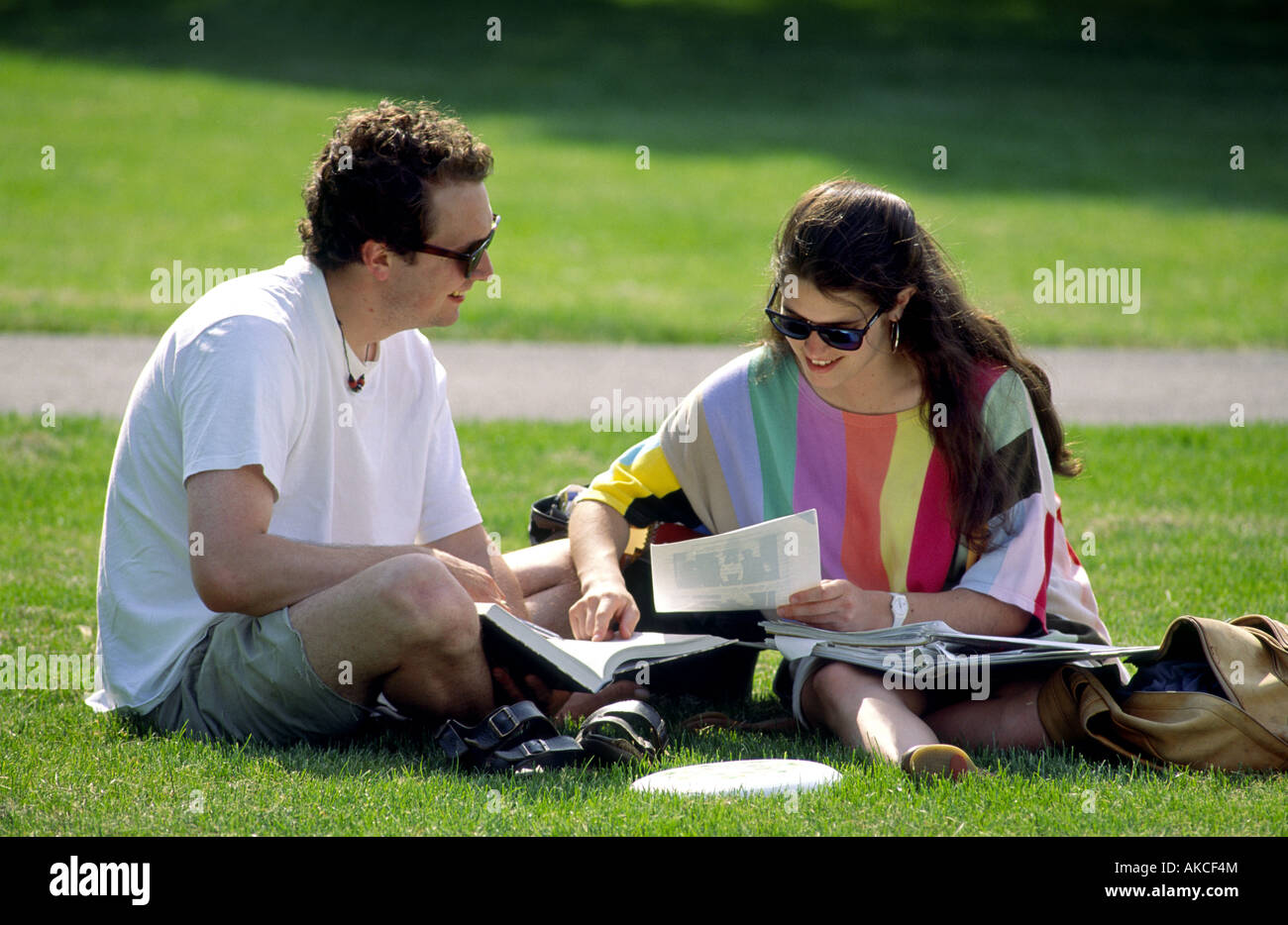 A college couple studies on a lawn on campus Stock Photo - Alamy