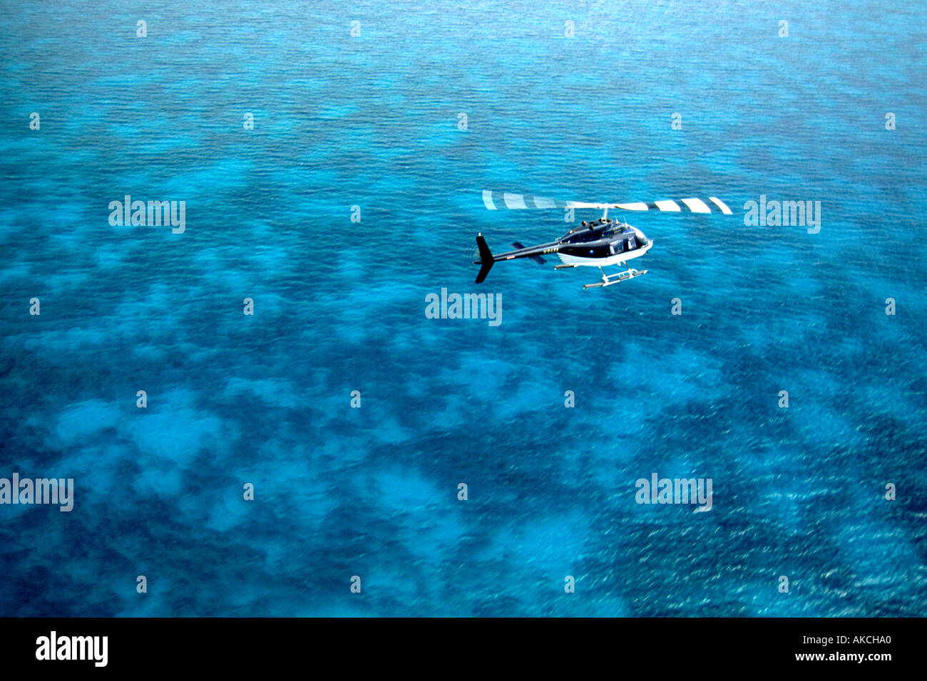 A helicopter flying over the Caribbean sea off the coast of Antigua ...