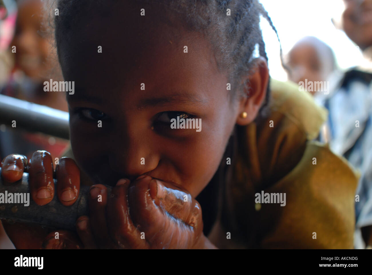 Girl drinking water from a spring that has been capped using money from ...
