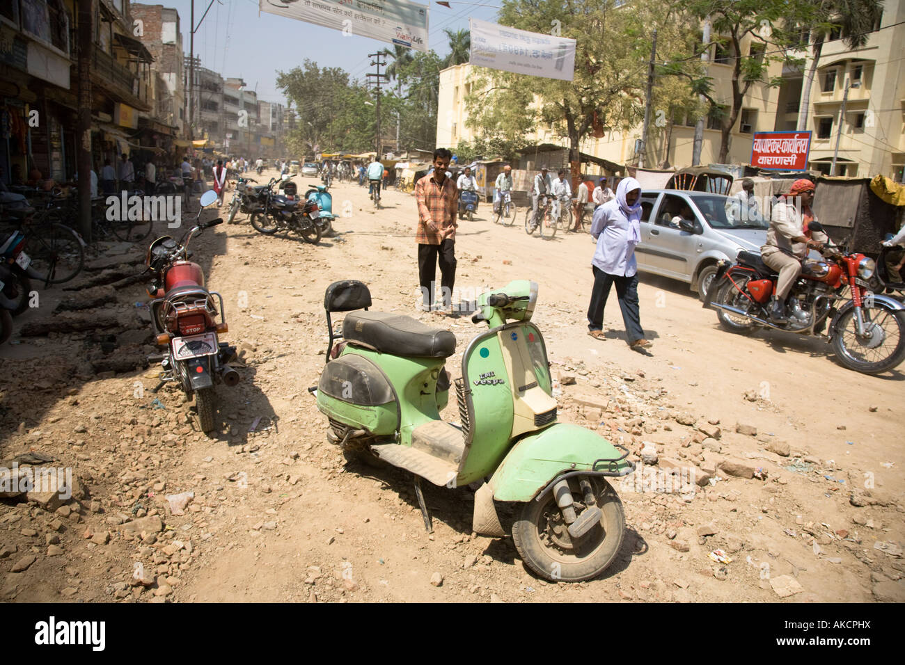 View along a hot, dusty, dirty street in Varanasi centre. Varanasi ...