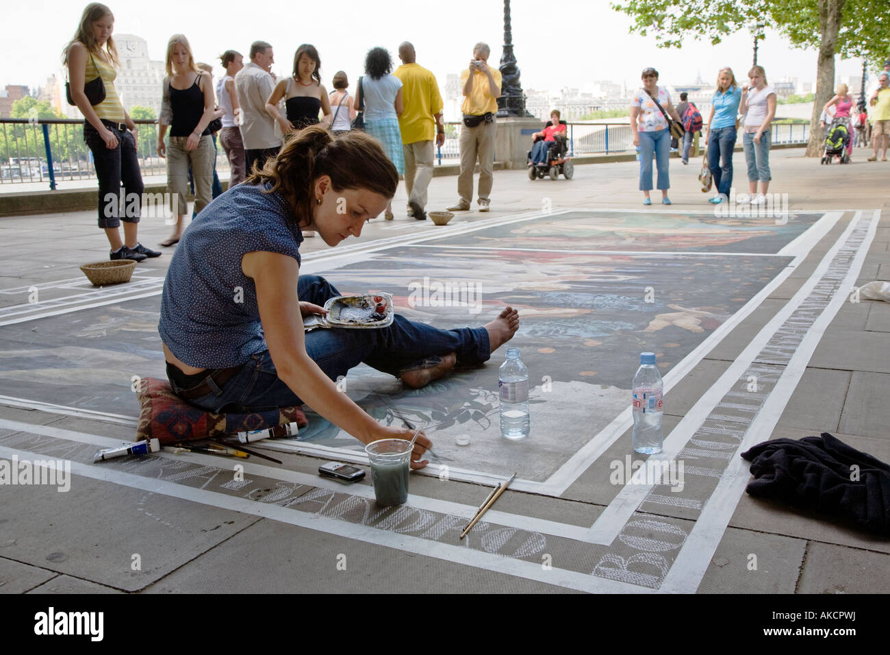 A pavement artist working on a very large mural. The mural represents ...