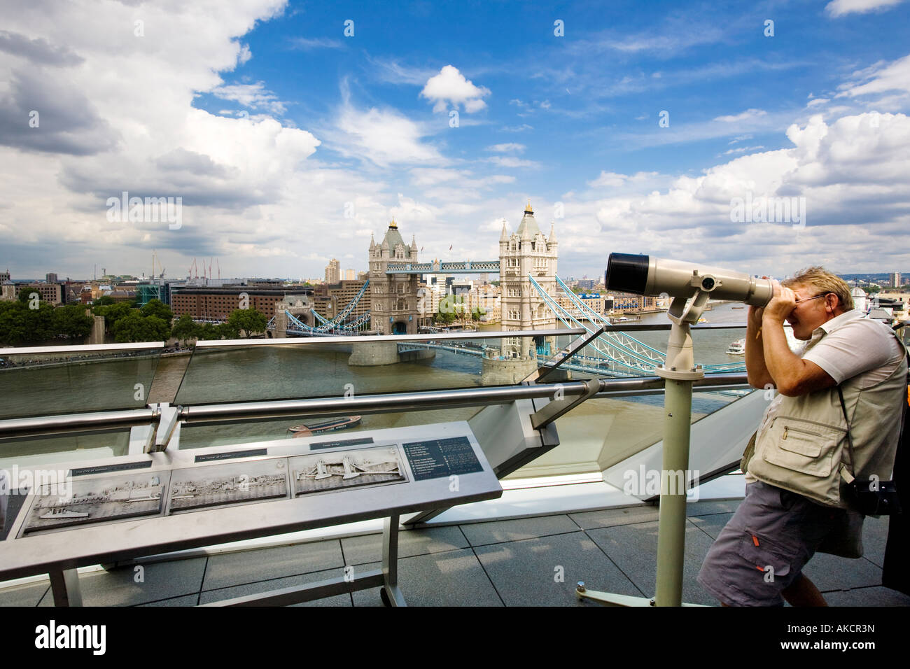 A tourist looking through a telescope on the roof of City Hall. Tower ...