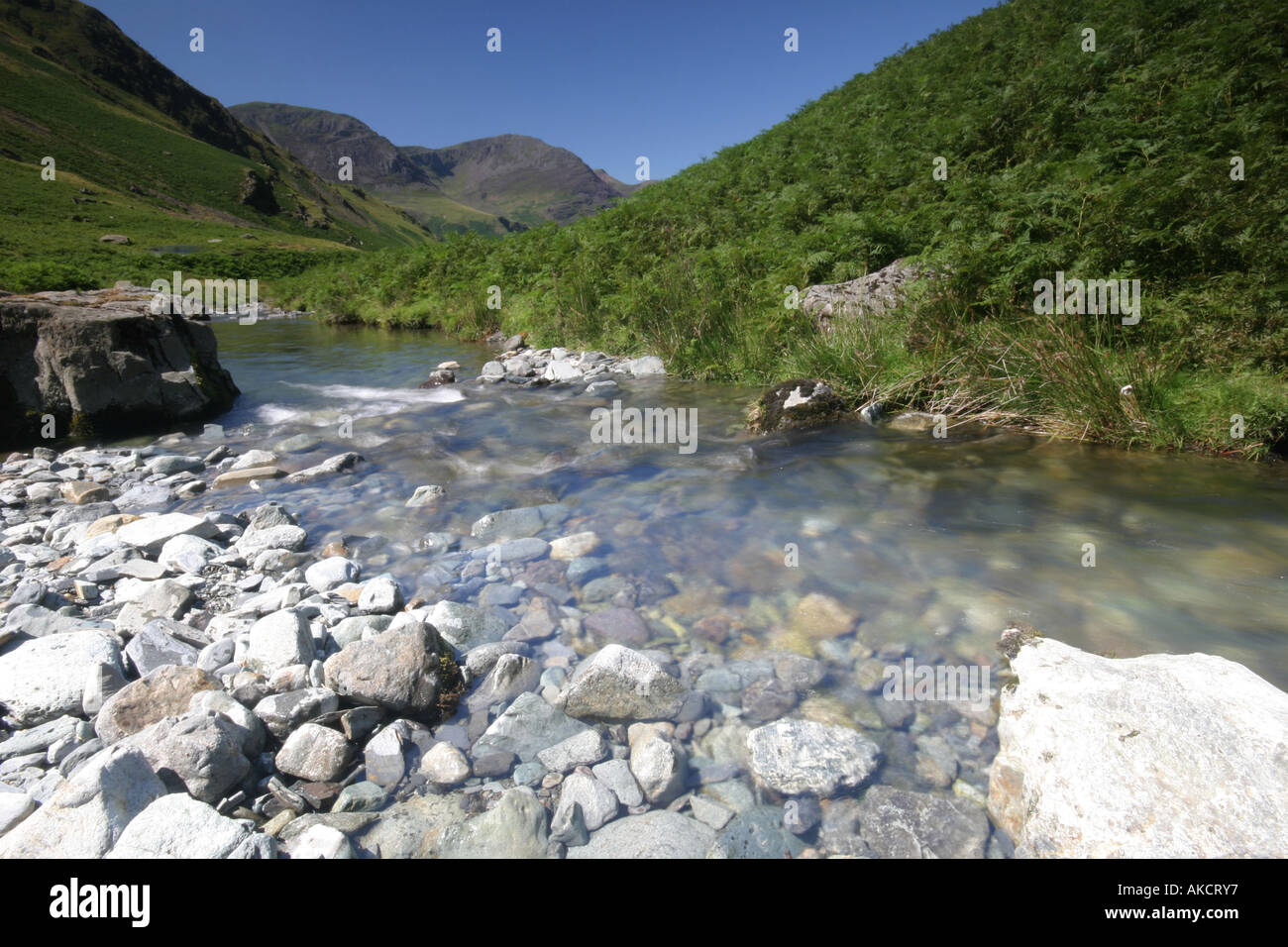 A Stock Photograph of a stream running through a valley down to ...