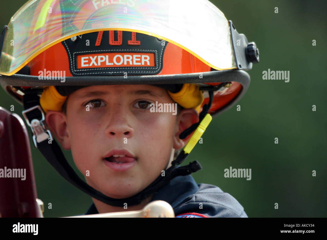 Young Fire Fighter Explorer with tongue out riding the back of the ...