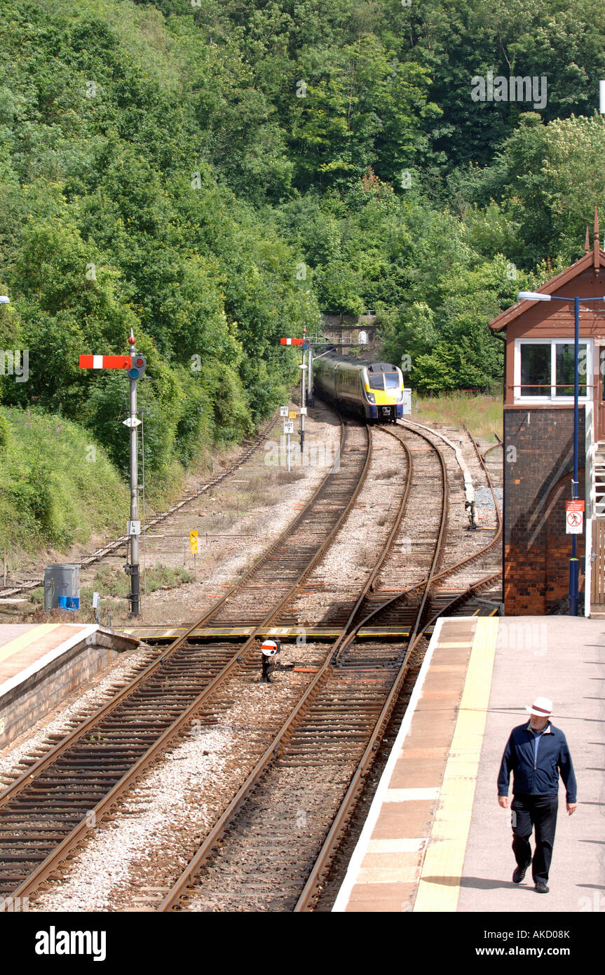 A MAN WALKS ALONG THE PLATFORM OF LEDBURY RAILWAY STATION AS A TRAIN ...