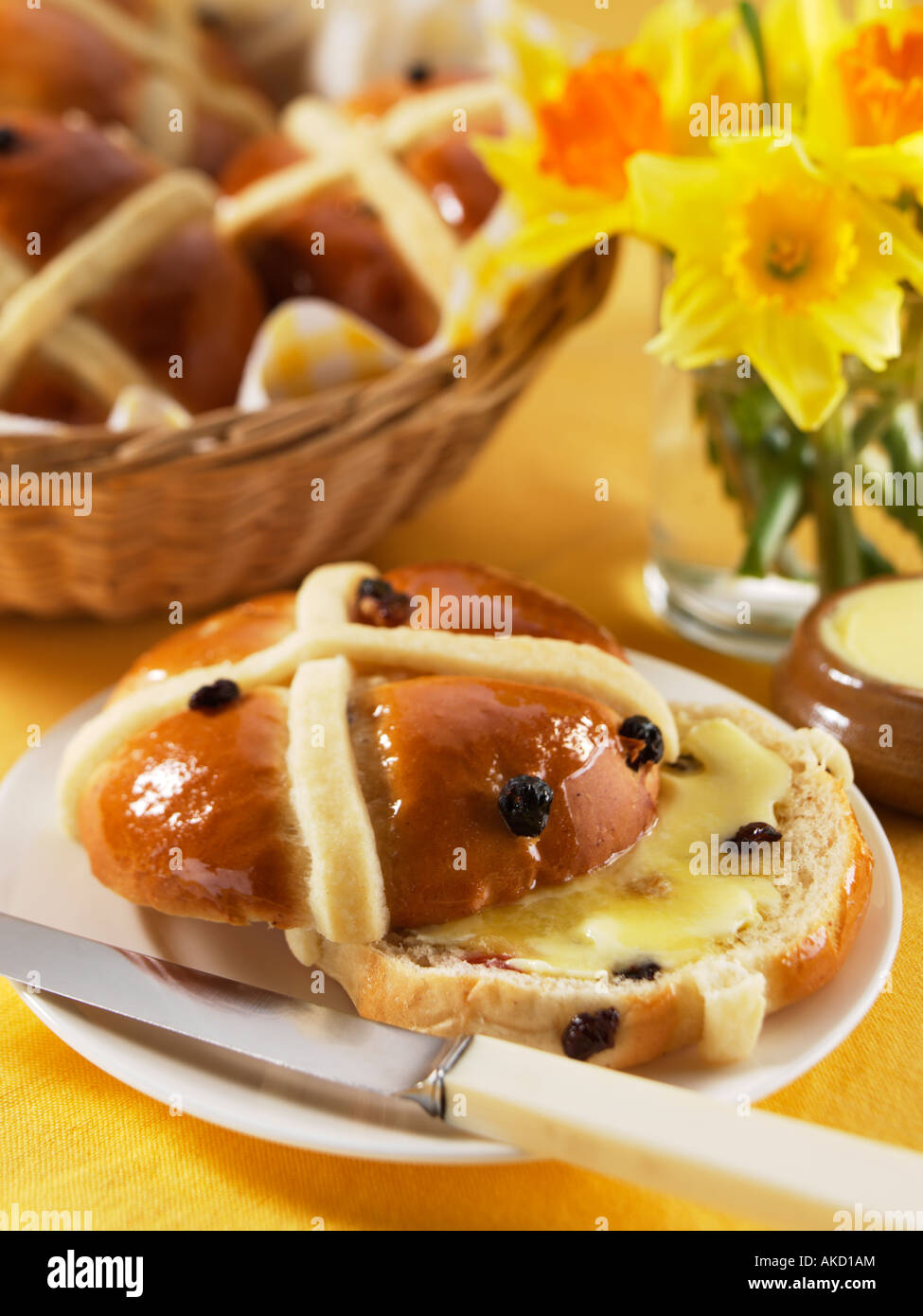 A single traditional vegetarian hot cross buns with a basket full of ...
