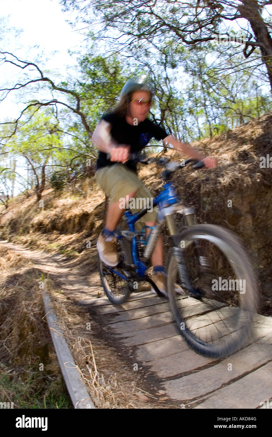 Riding a mountain bike through the bush fast Stock Photo - Alamy