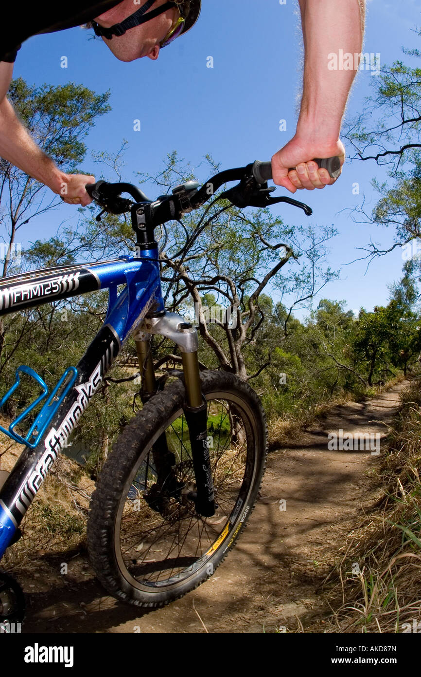 Riding a mountain bike through the bush fast Stock Photo - Alamy
