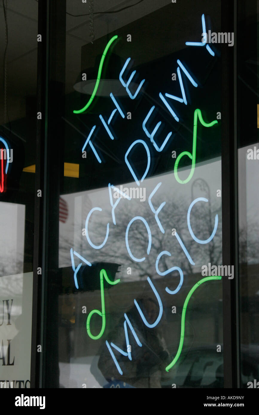 A neon sign on a music store front window the Academy of Music Stock ...