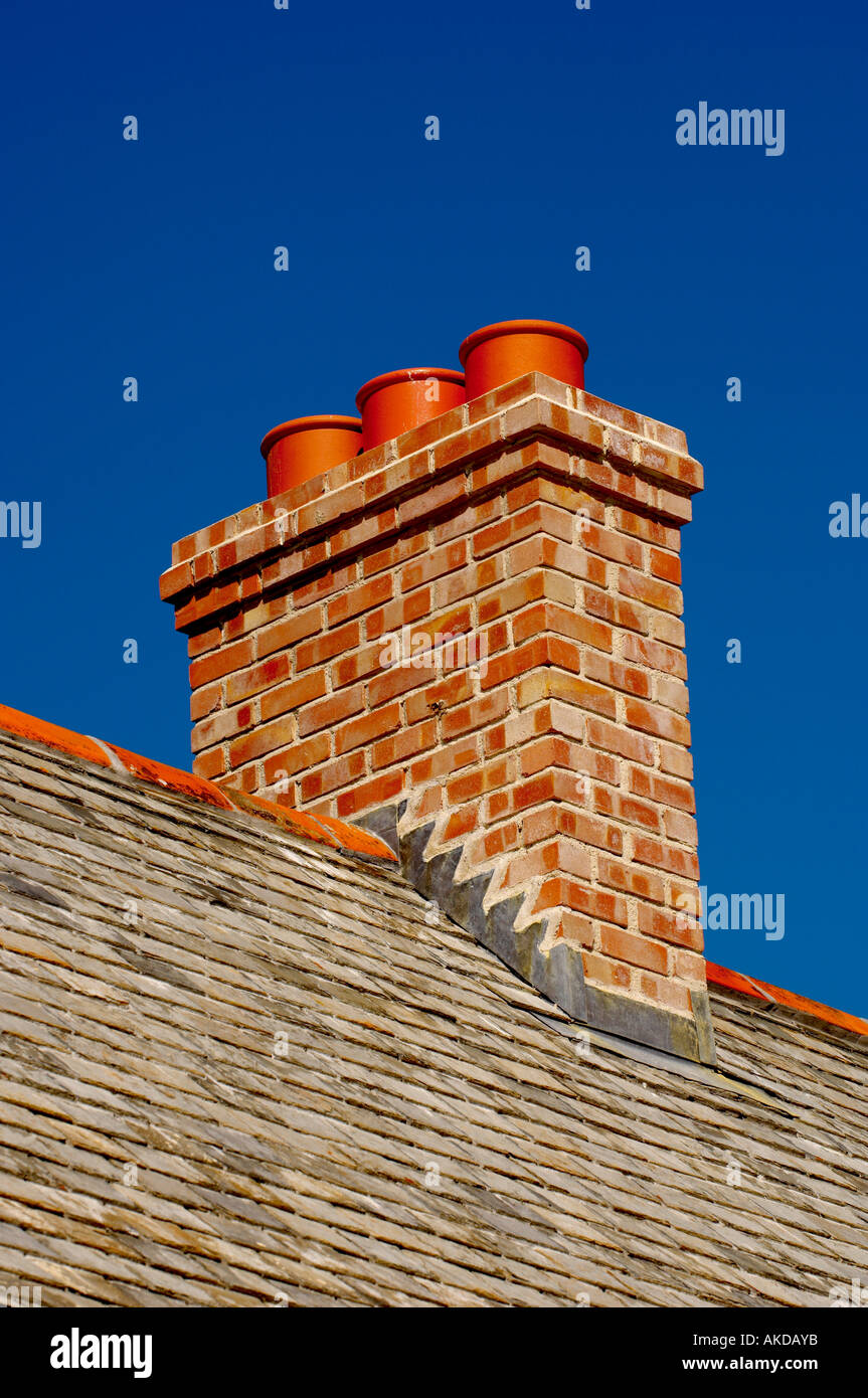 Brick chimney stack with terracotta chimney pots atop a traditional ...
