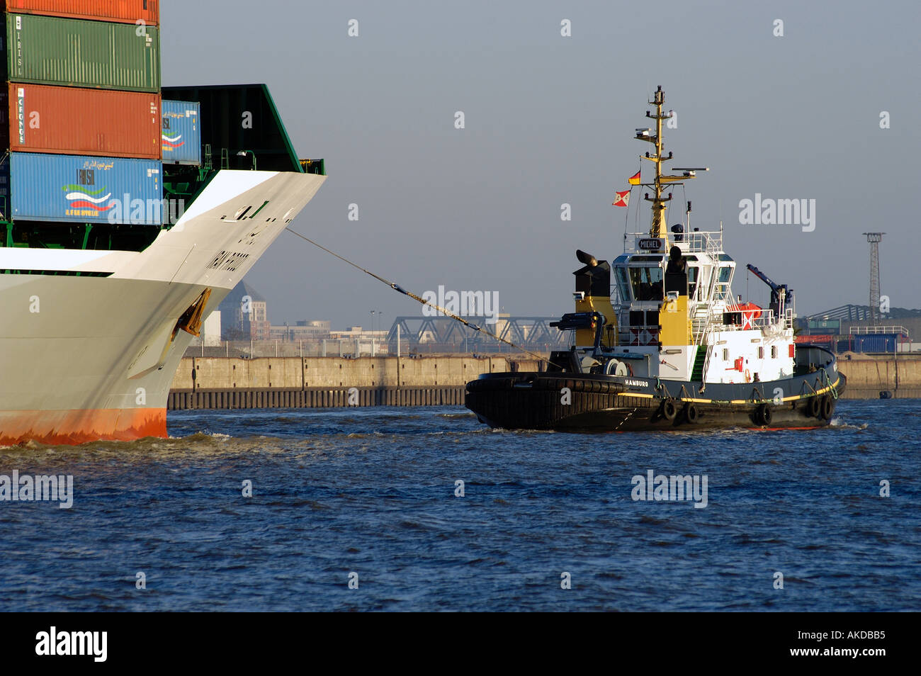 Tugs moving a container ship in the port of Hamburg Germany Stock Photo ...