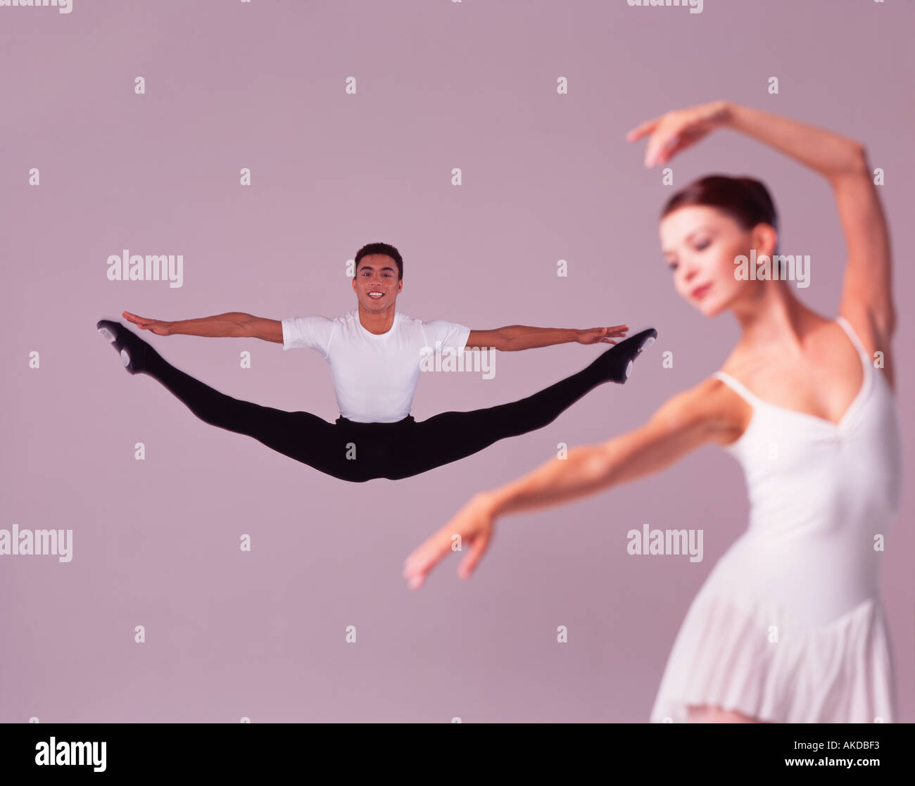 jumping dancer behind elegantly posed female dancer in foreground Stock ...