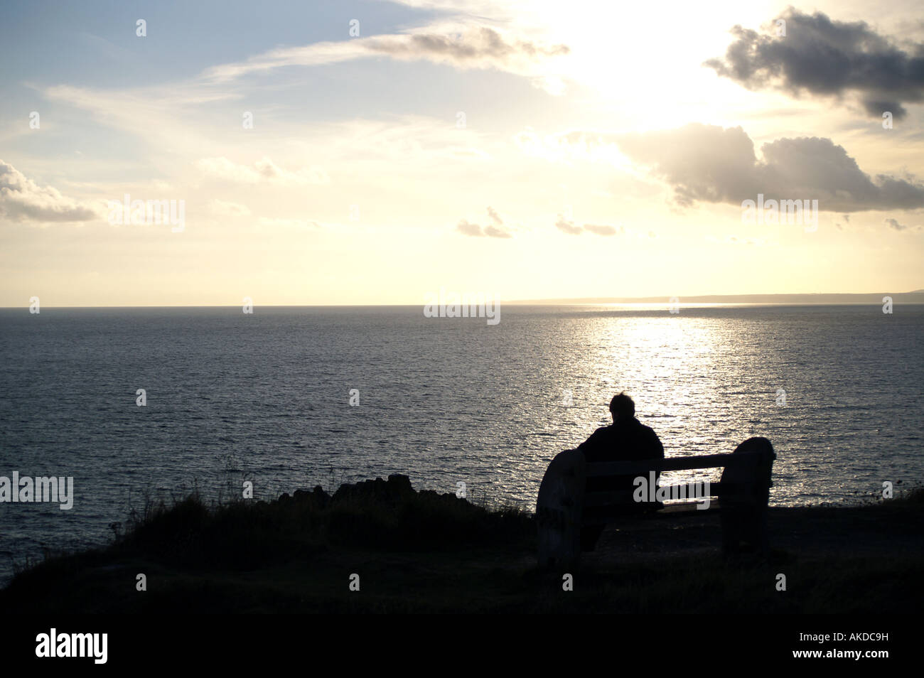 Contemplating the sunset above Mullion Harbour Stock Photo - Alamy