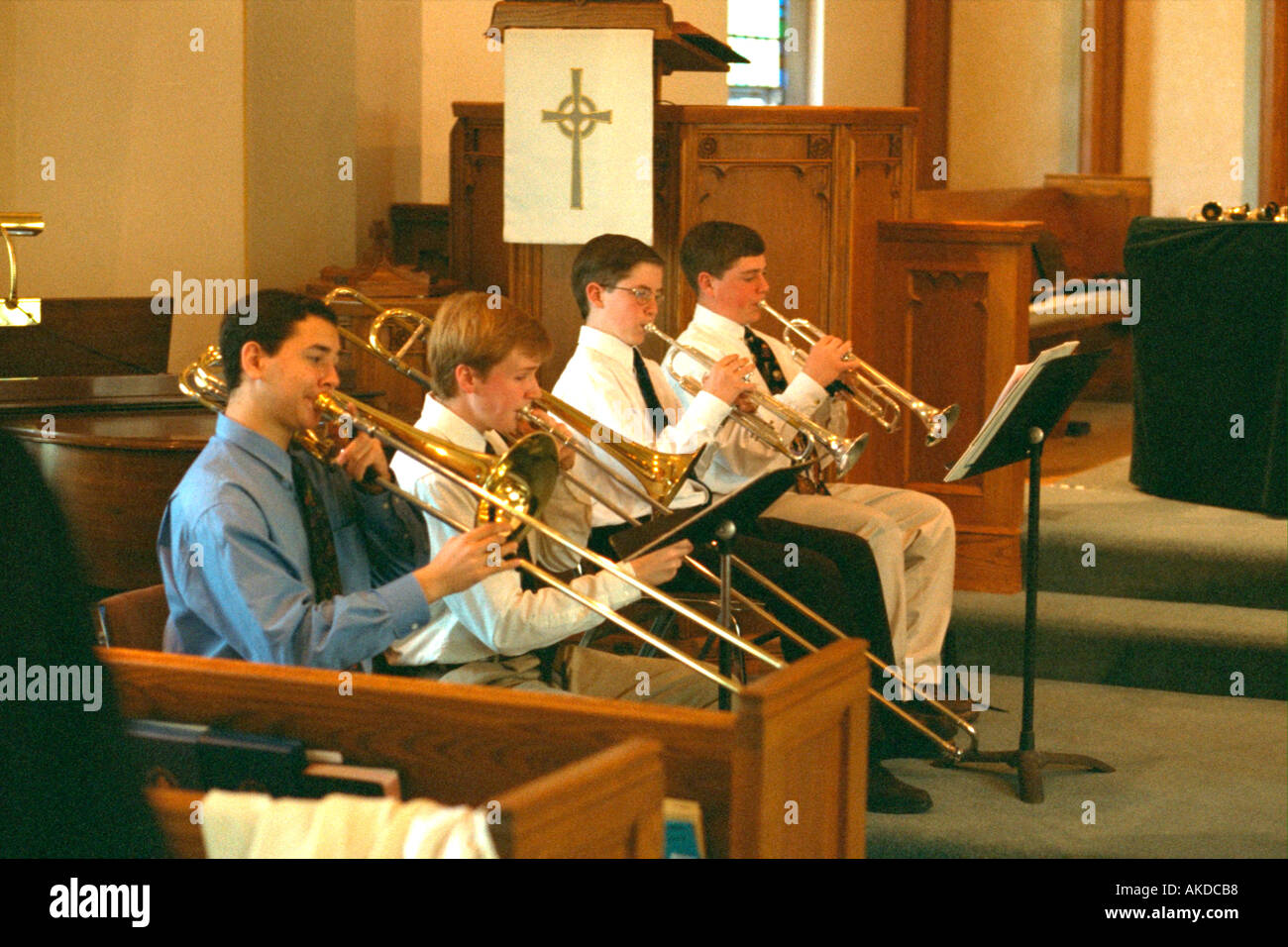 Teen boys age 15 playing brass trombones and trumpet instruments in ...