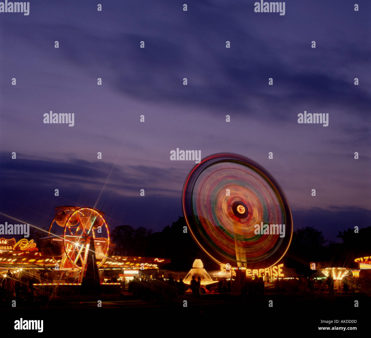 a Fun Fair on Ealing Common shot at dusk with the large wheel. and ...