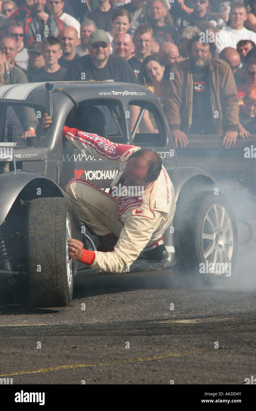 Stunt Man Terry Grant changes a tyre on a wheelspinning car ...
