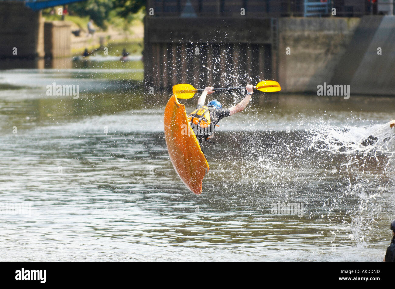 Airborne kayaker in his yellow playboat sliding off a ramp into the ...