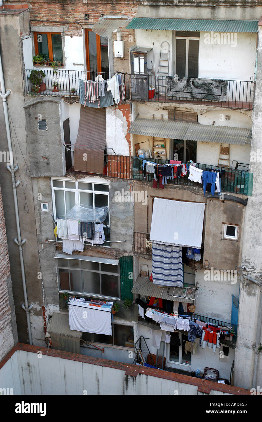 A rear view of an apartment building with laundry drying outside of ...