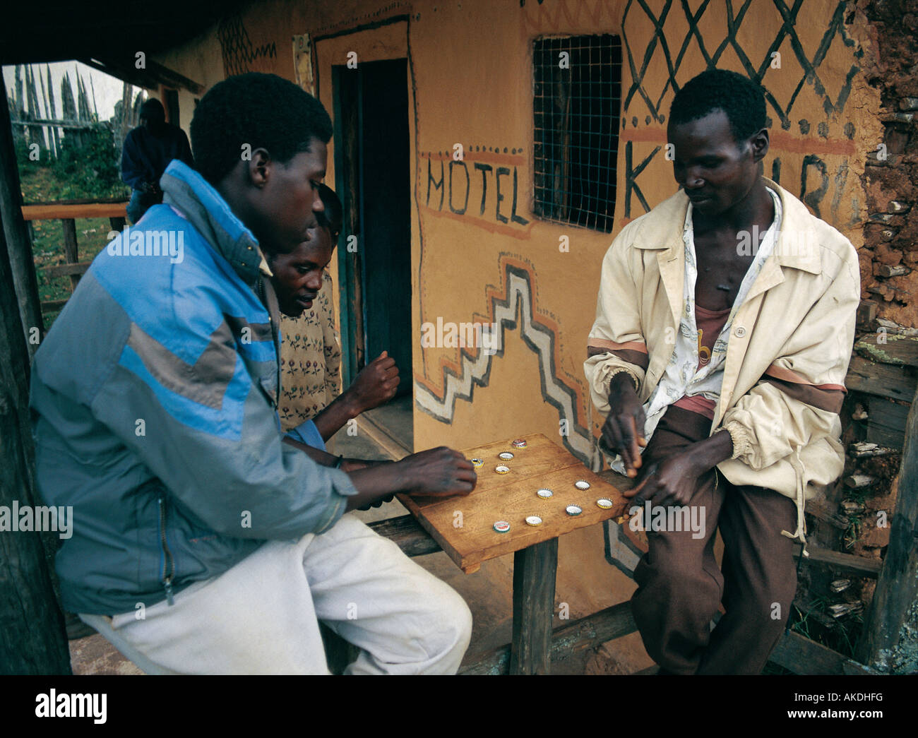 Two local African men play indigenous drafts with bottle tops Embobout ...