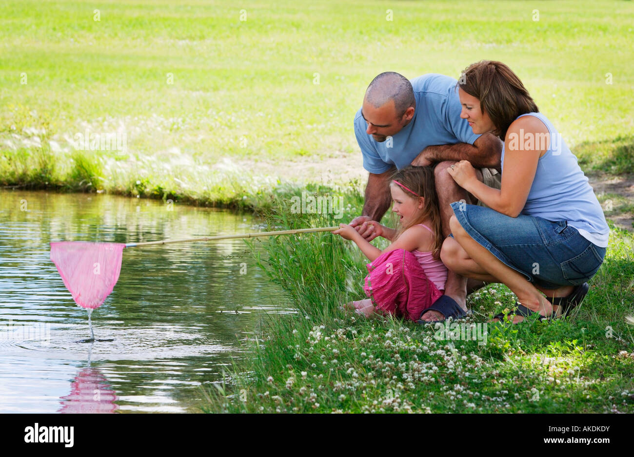 Family down by a pond Stock Photo - Alamy